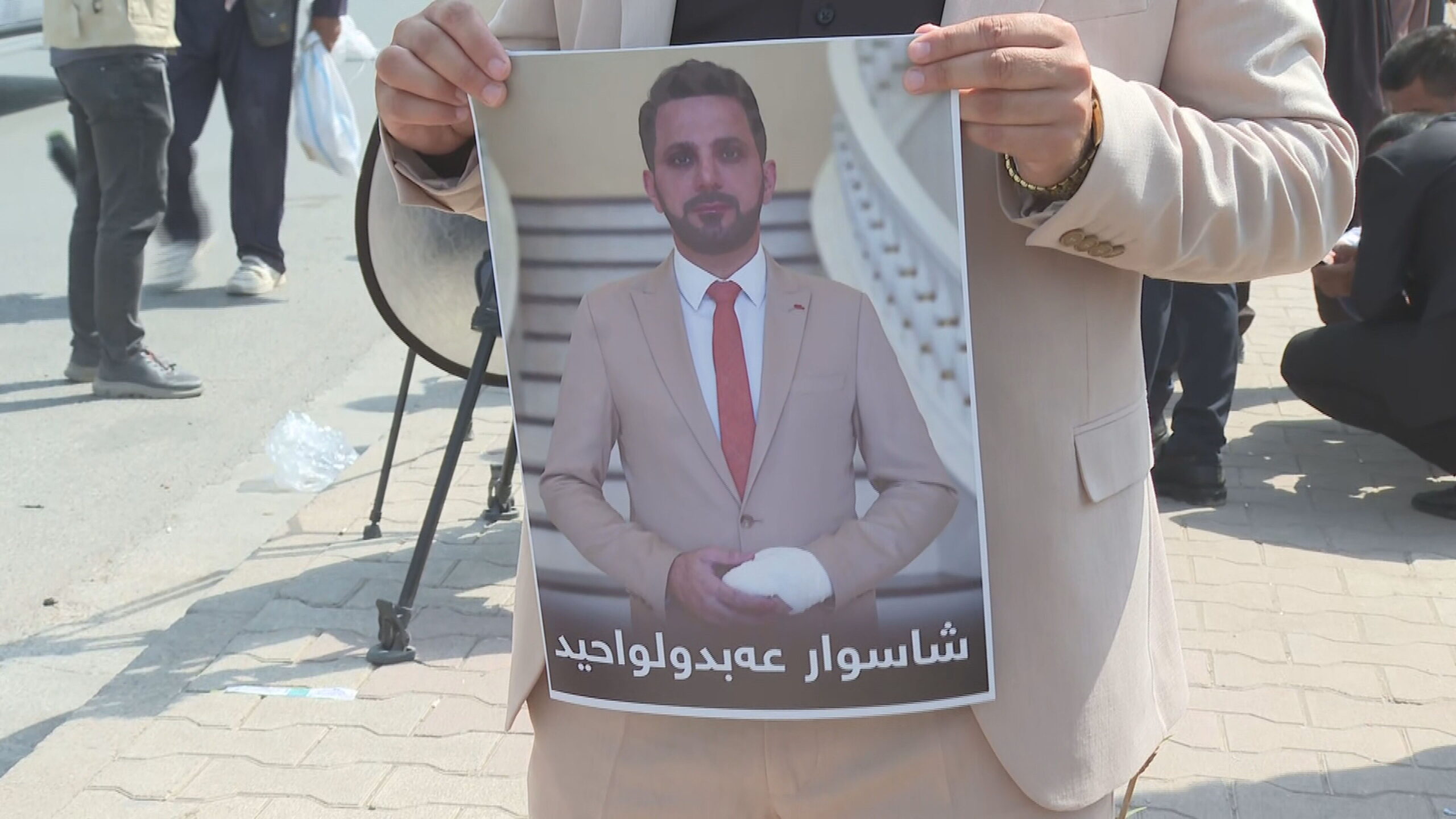 Supporters hold a poster of Shaswar Abdulwahid outside the Sulaymaniyah ...